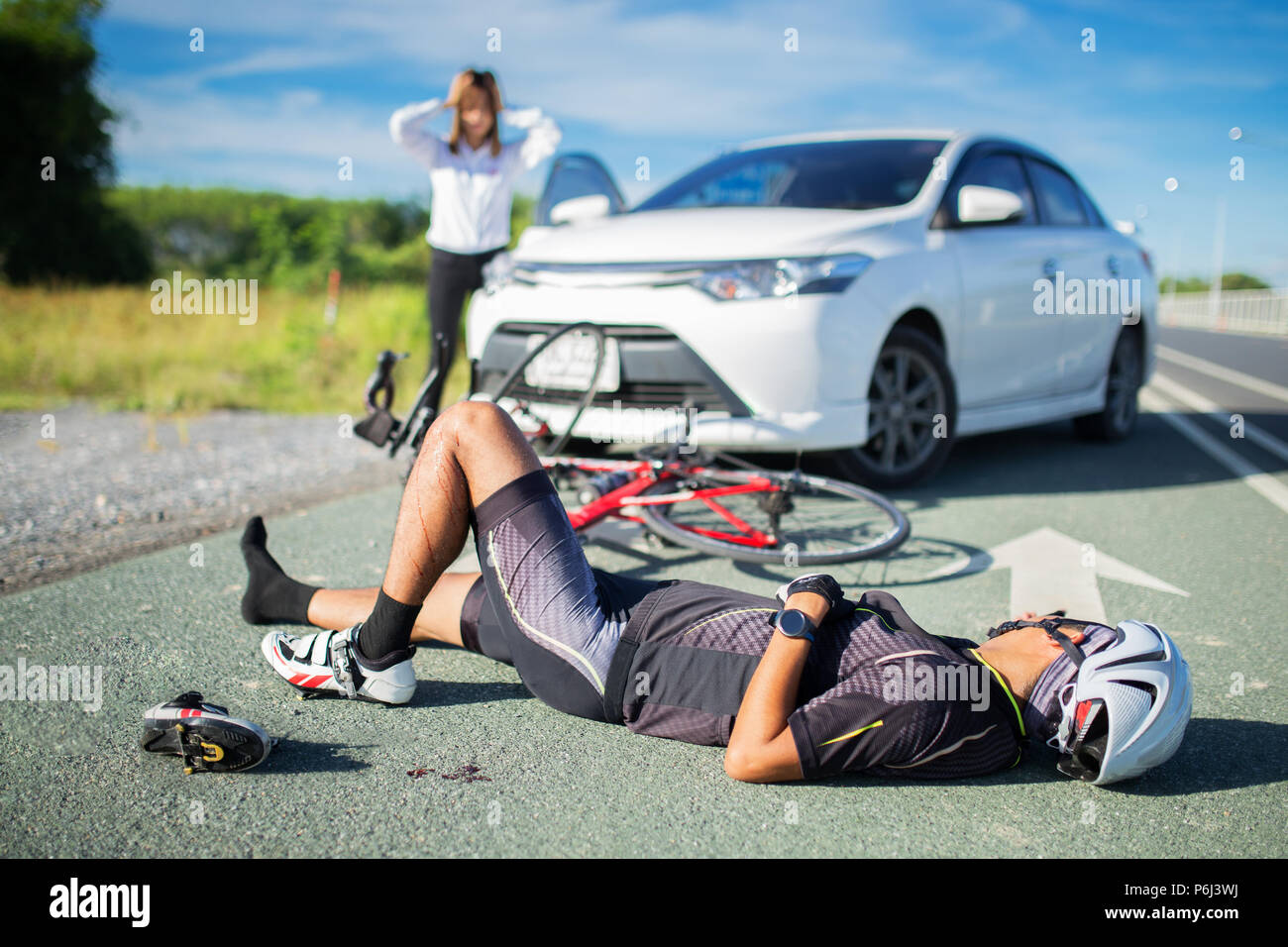Unconscious male cyclist lying on road after road accident, Selective ...