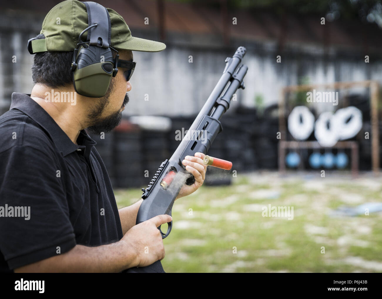 View of a man with a shotgun reload the cartridge Stock Photo - Alamy