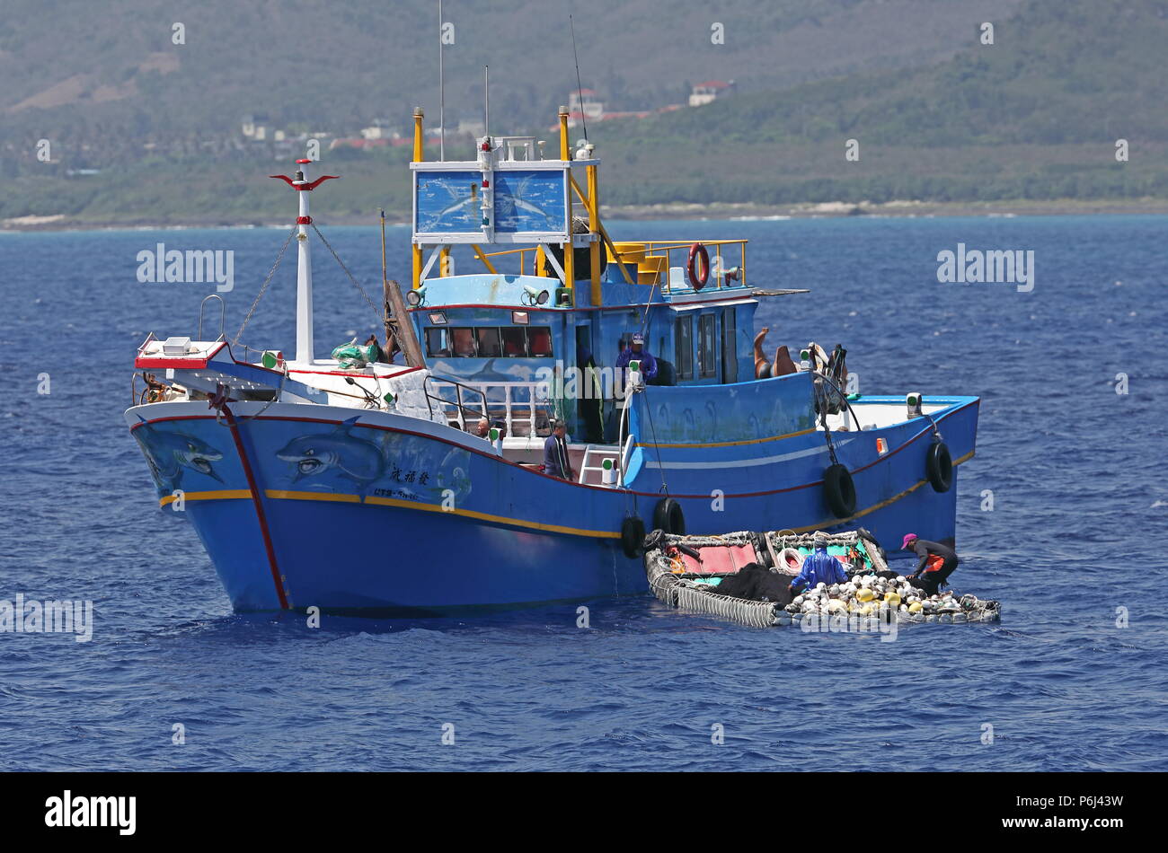 fishing boat loading nets into small boat Taiwan April Stock Photo - Alamy
