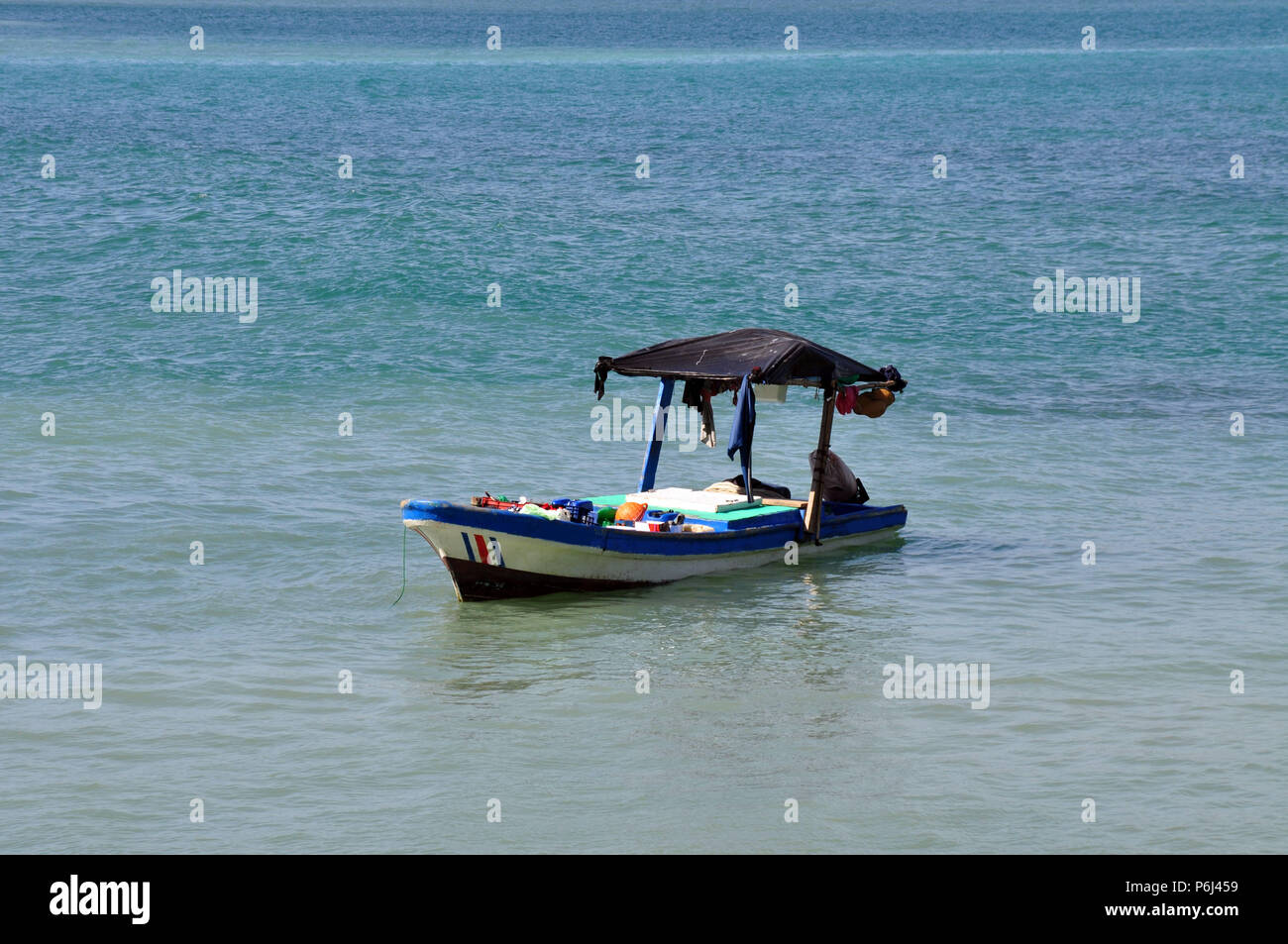 Small Fishing Boat anchored in the ocean Stock Photo - Alamy