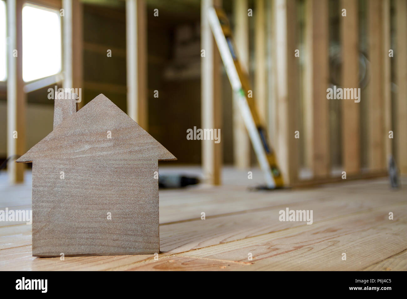 Close-up of simple small brown model house on blurred building tools ...
