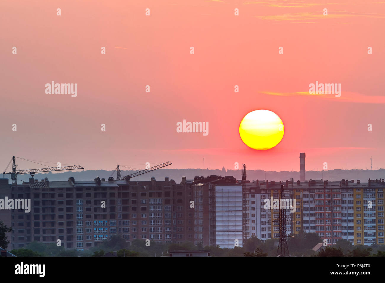 Beautiful sunrise in city suburbs. Big bright white and yellow sun over ...