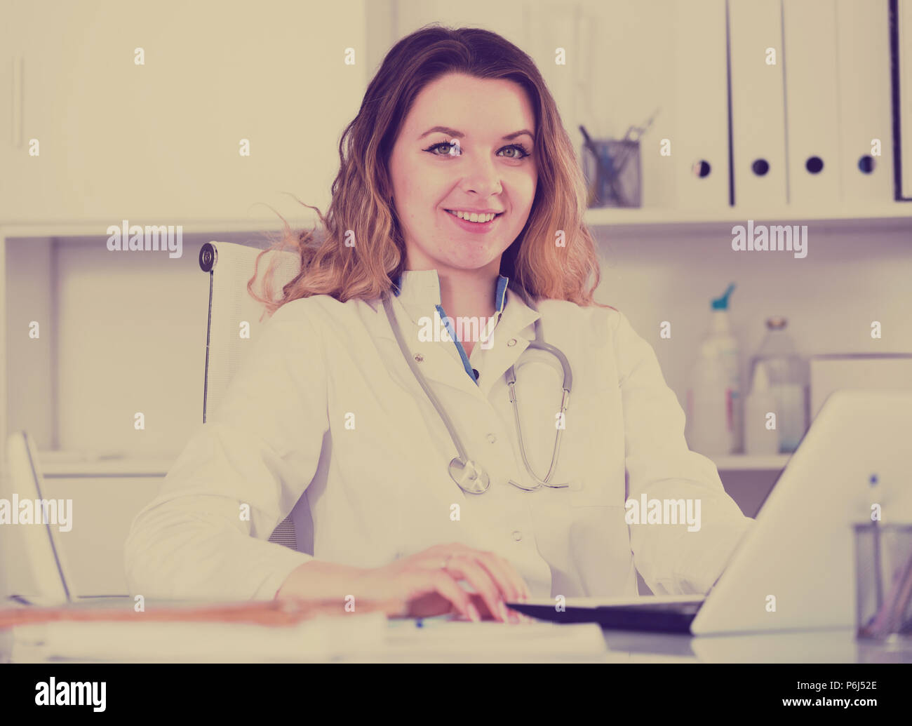 Young smiling female working in medical Center at the laptop Stock ...