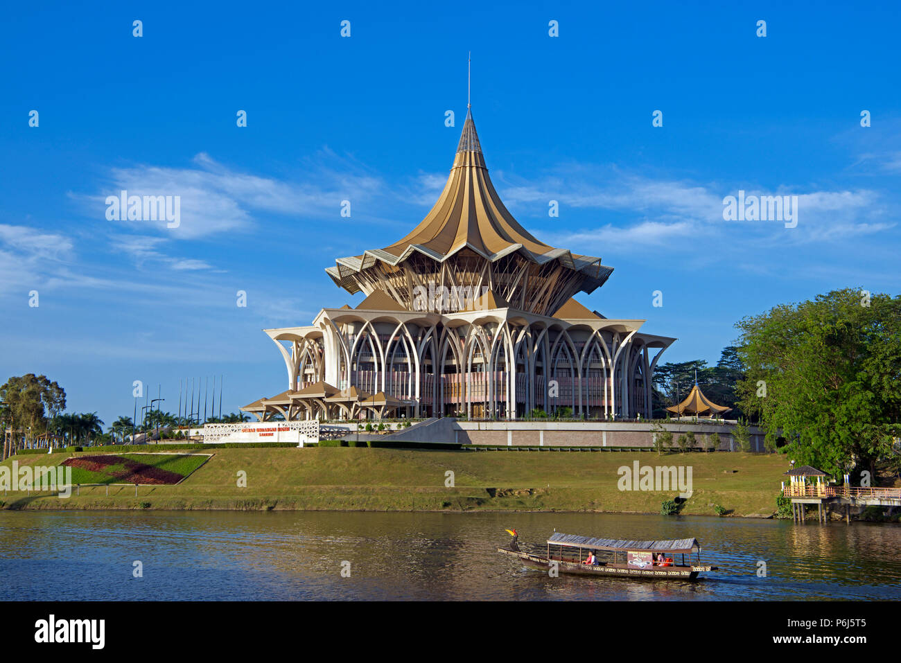 Sarawak State Assembly building and small boat on Sarawak River Kuching ...