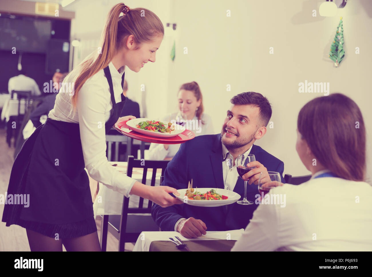 Woman waiter is giving dish to client in restaurante indoor Stock Photo ...