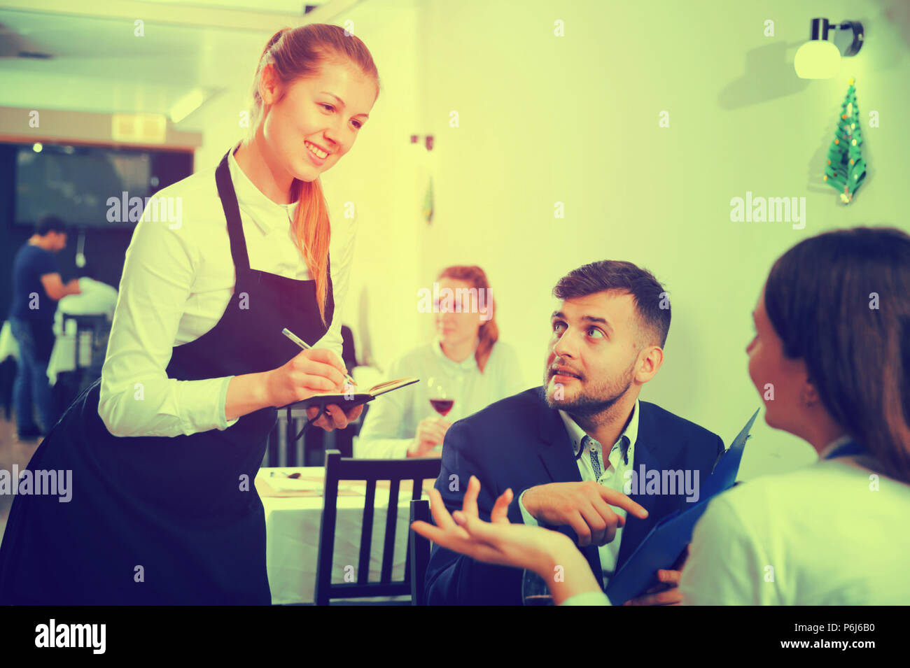 Couple is giving order to female waiter in luxury restaurante indoor ...