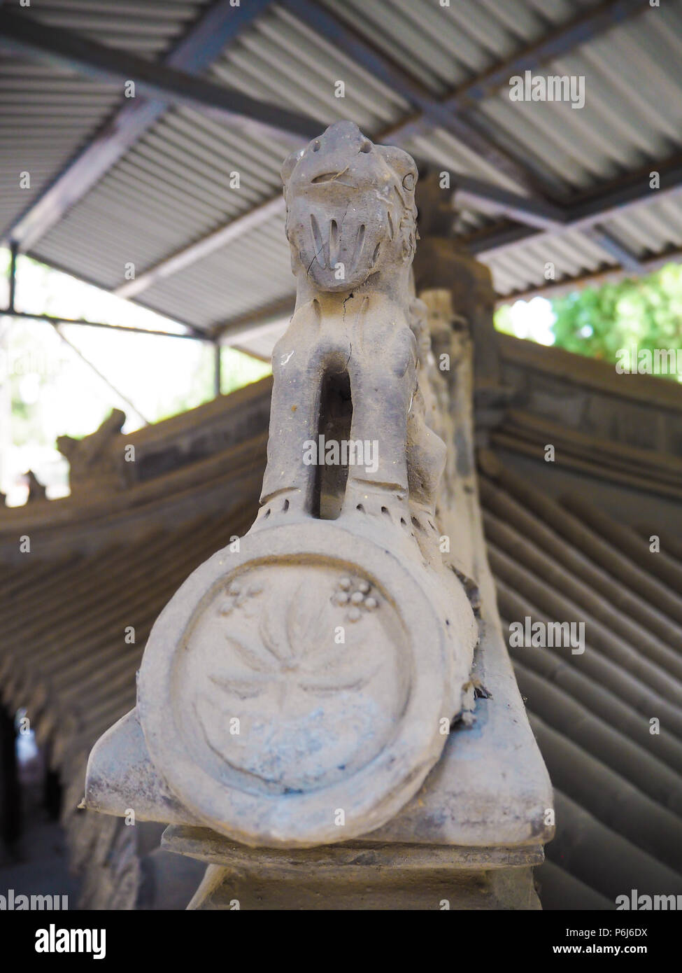 Faded blue clay mythical roof figurines and eaves ready to be renovated ...