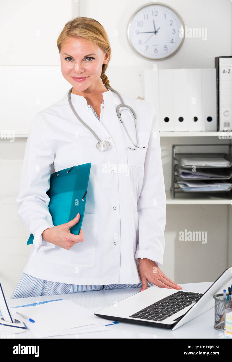 portrait of young smiling italian doctor in uniform with clipboard in ...