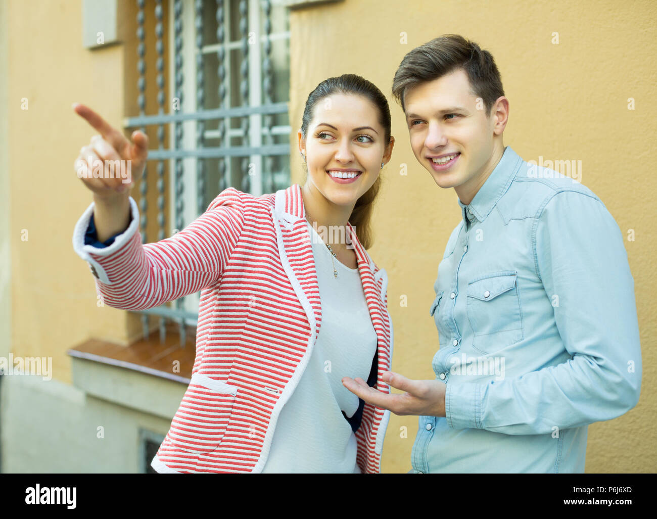 Positive traveller asking smiling woman to show him direction Stock ...