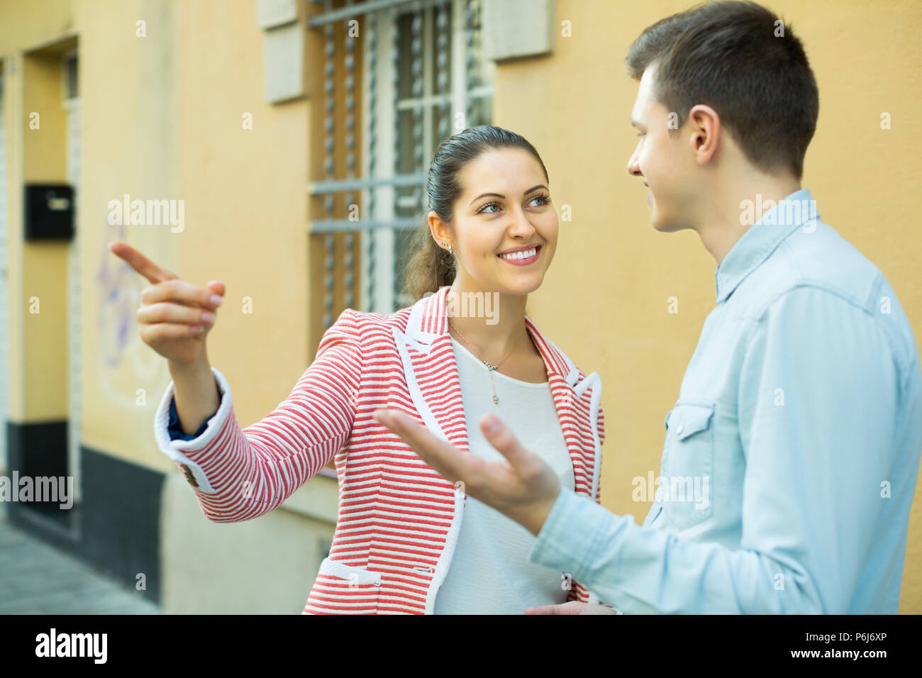 Traveller asking happy young woman to show him direction Stock Photo ...