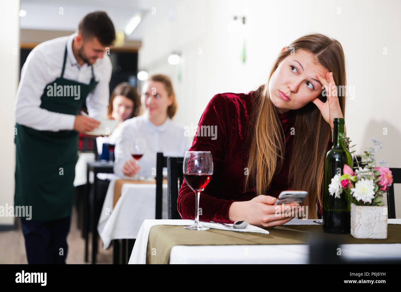 Sad woman is dining in luxury restaurante alone indoor Stock Photo - Alamy