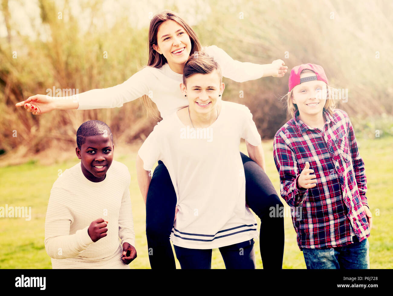Portrait of laughing friends running on field in sunny day Stock Photo ...