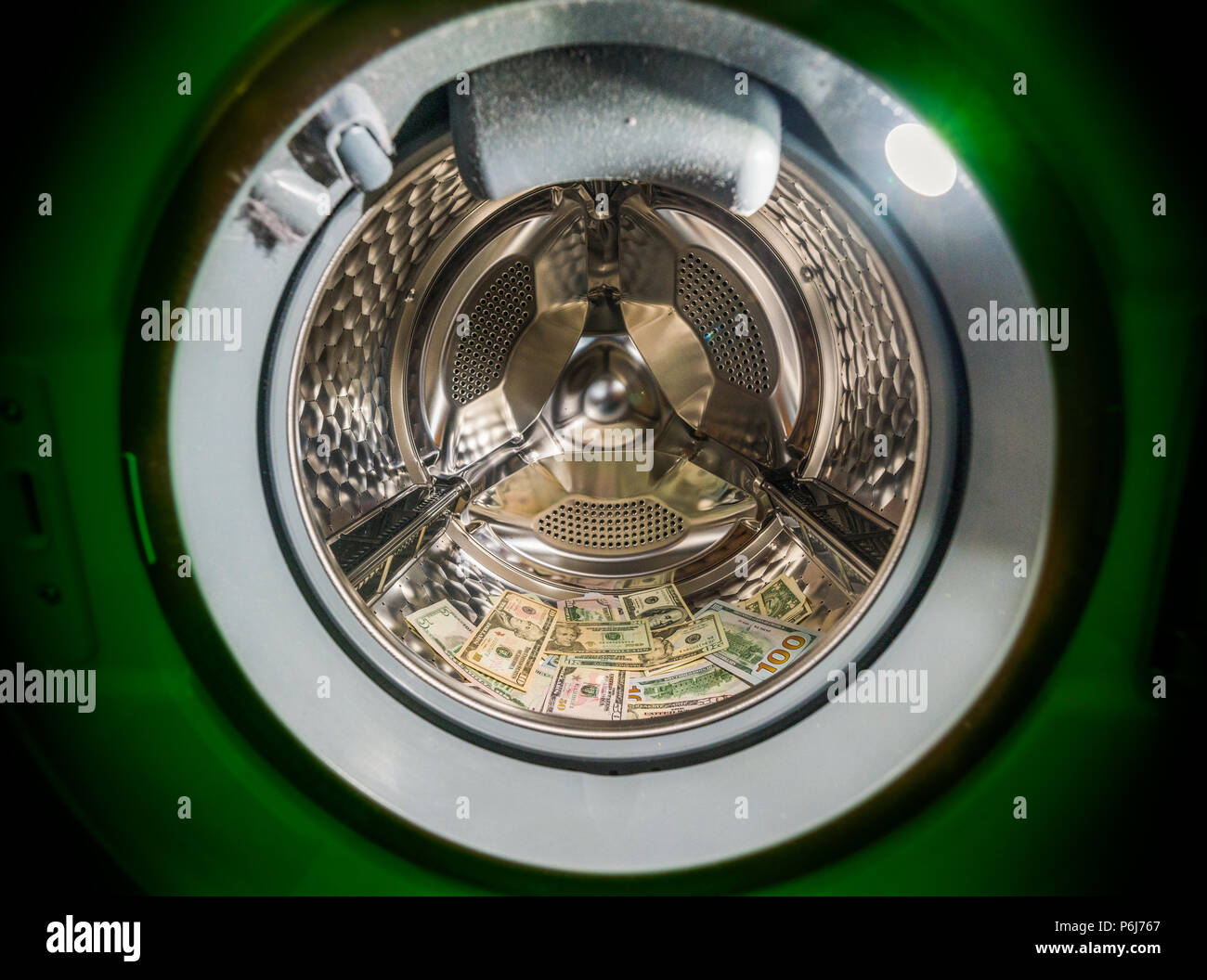 Money laundering symbol, US dollar banknotes in washing machine with ...