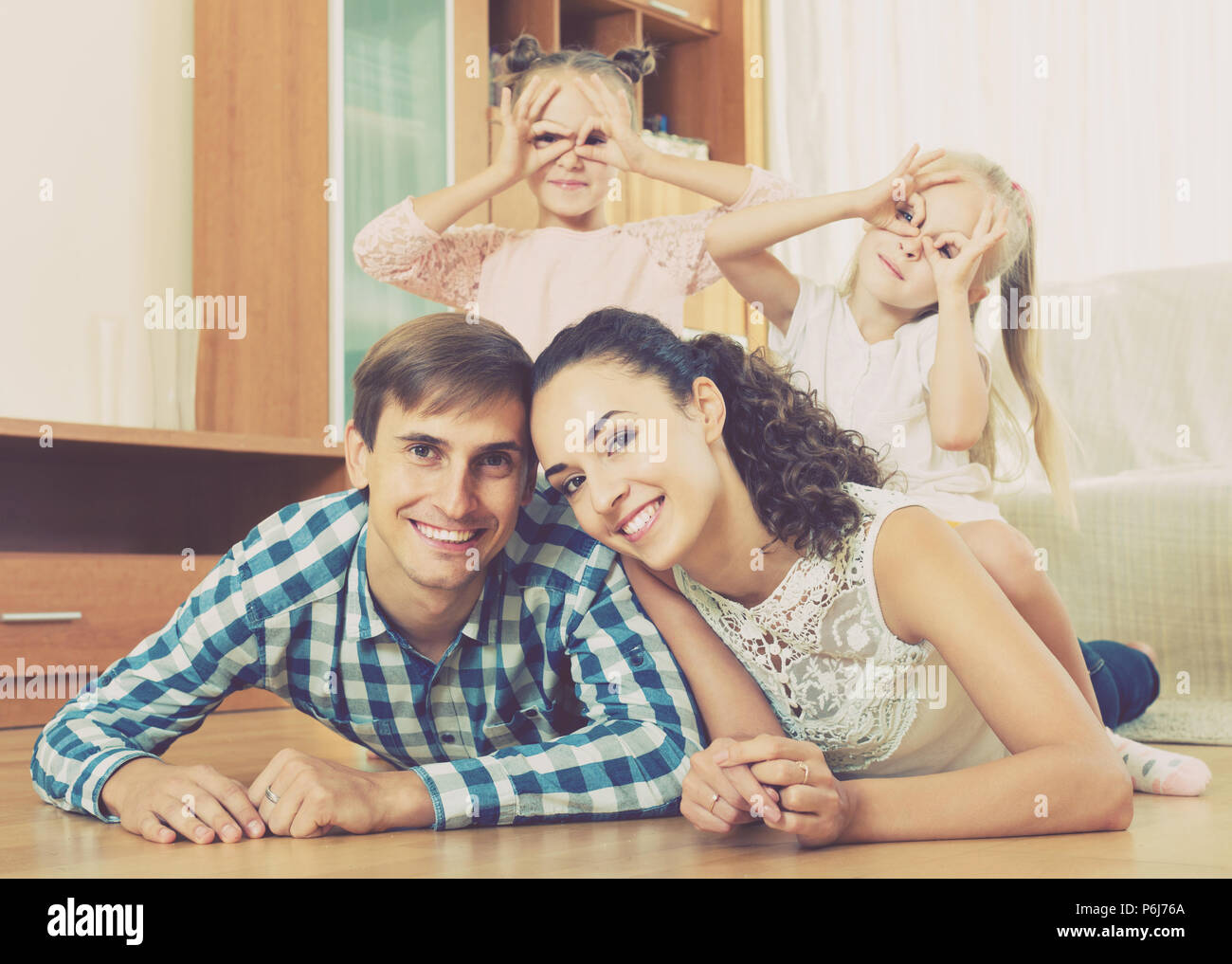 Family values: portrait of positive spanish parents with little girls ...