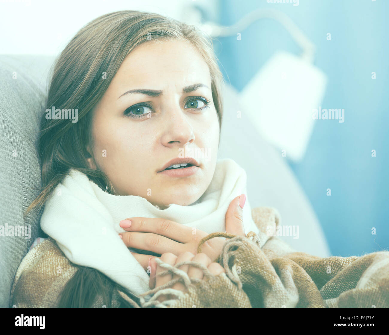 Young woman catching cold, wrapping in blanket Stock Photo - Alamy