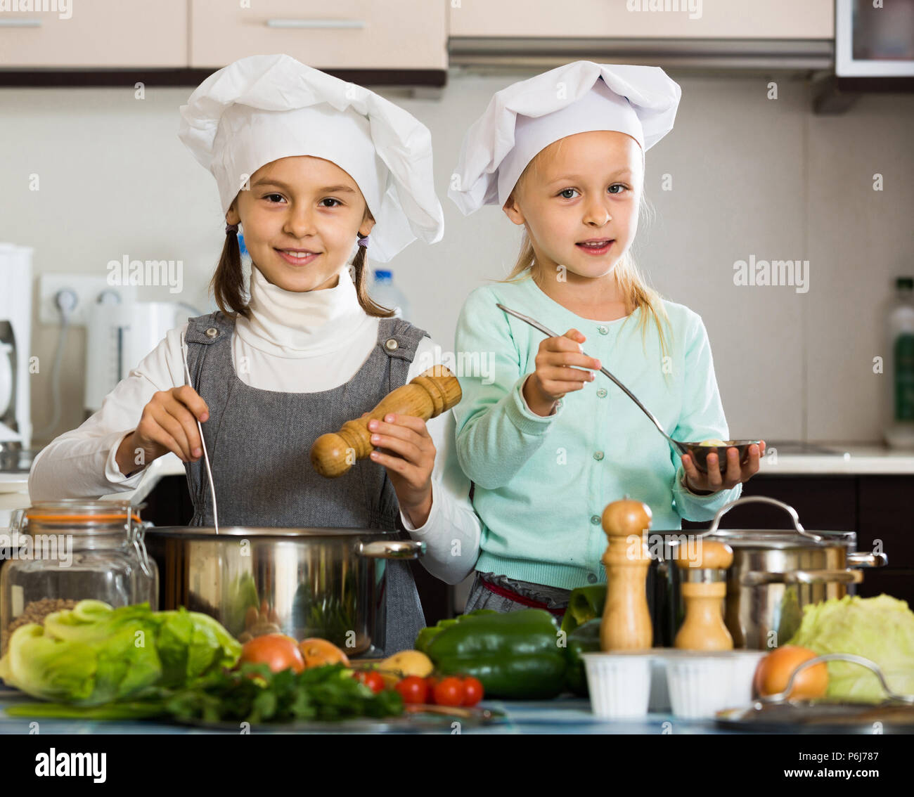 Two happy spanish girls preparing vegetables and smiling indoors Stock ...