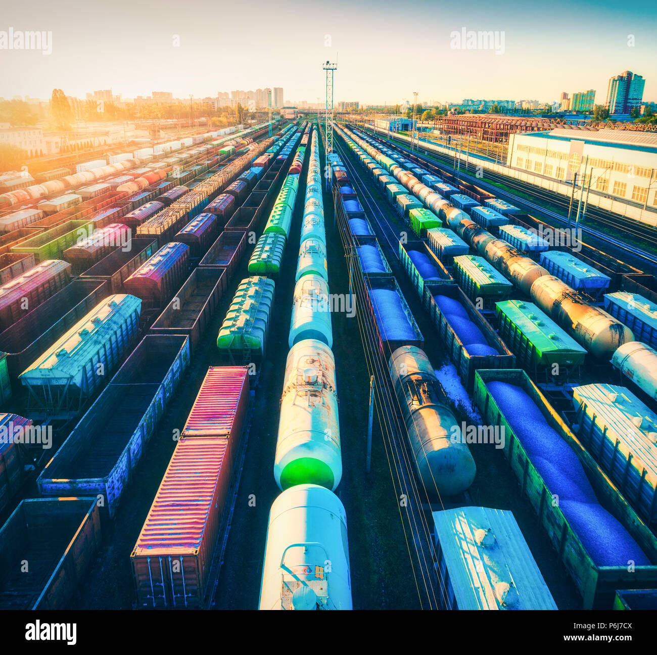 Aerial view of colorful freight trains at sunset. Cargo wagons with ...