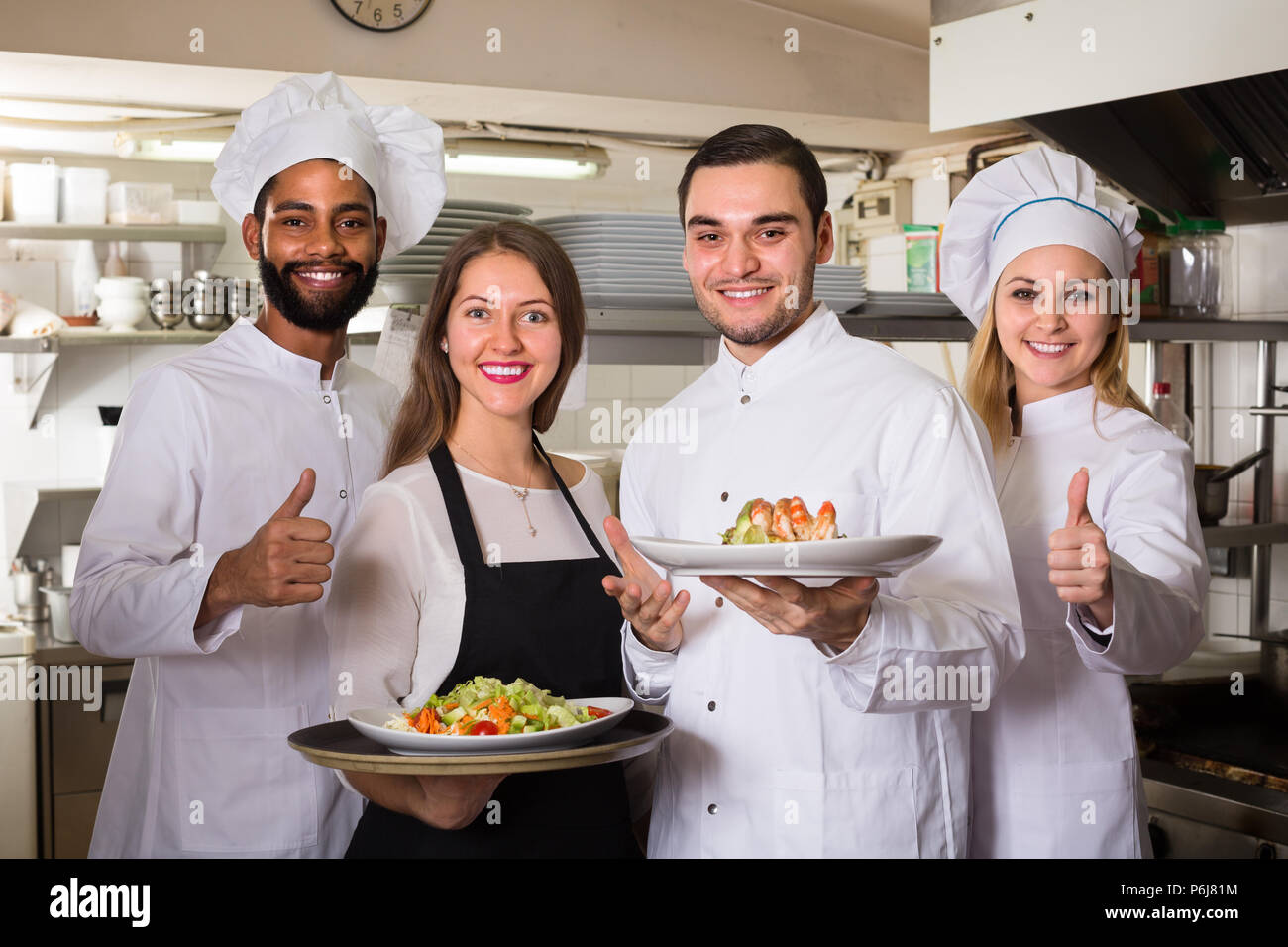 waitress and cooking team at professional kitchen in restaurant Stock ...