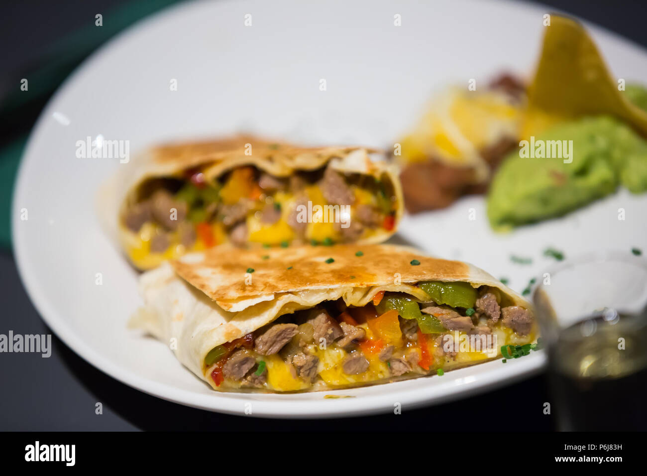 Traditional Tex-Mex burrito served guacamole in restaurant Stock Photo ...