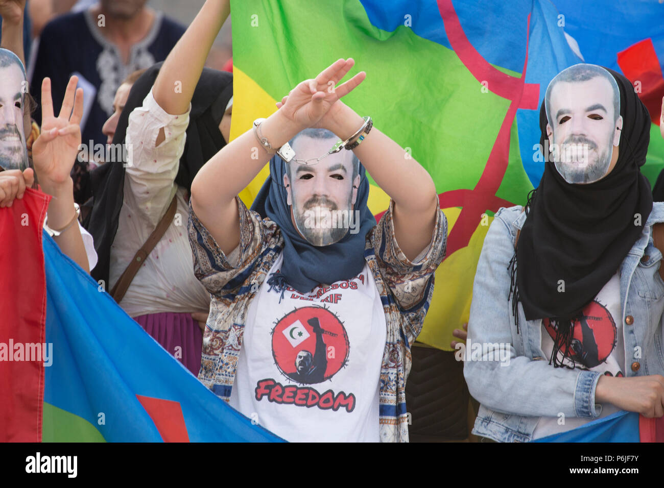 Demonstrators with handcuffs and face masks are seen during the protest ...