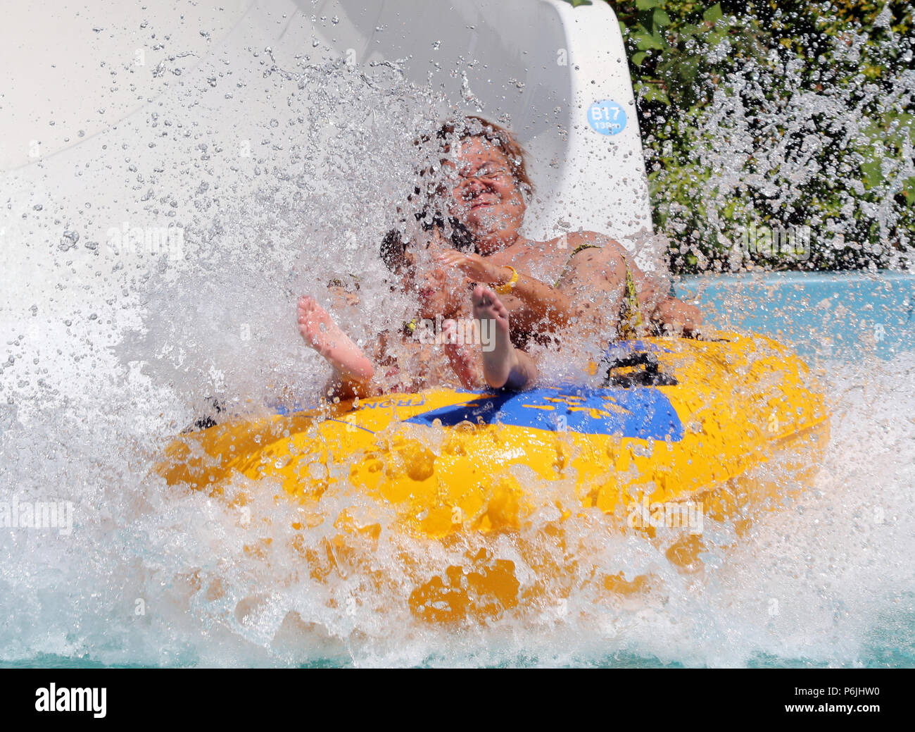 Tokyo, Japan. 30th June, 2018. People slide into a swimming pool as the ...