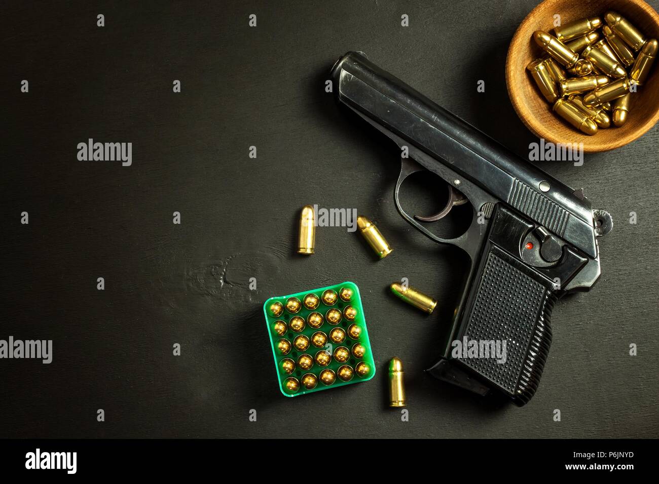 Pistol on black background. Gun and cartridges on the table. Right to ...