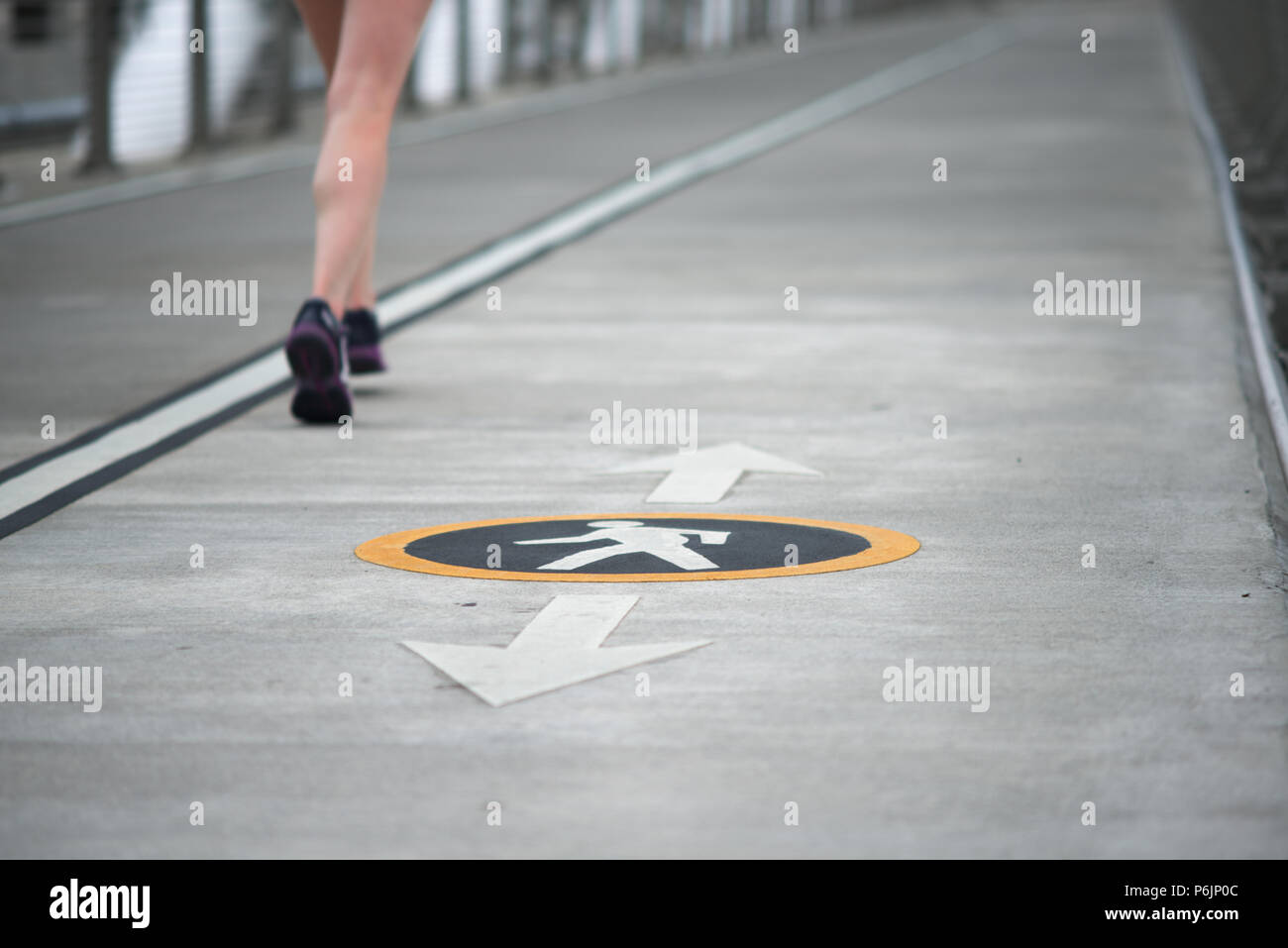 Label on pavement designating a pedestrian walking path, women's legs ...