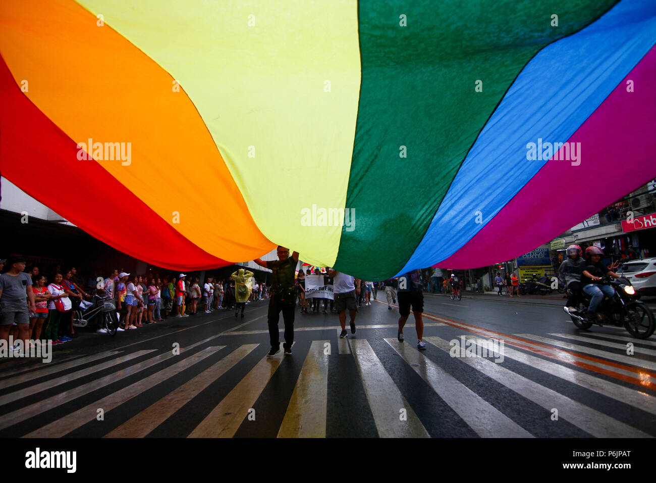 Pride march participants hold a rainbow flag during the parade ...