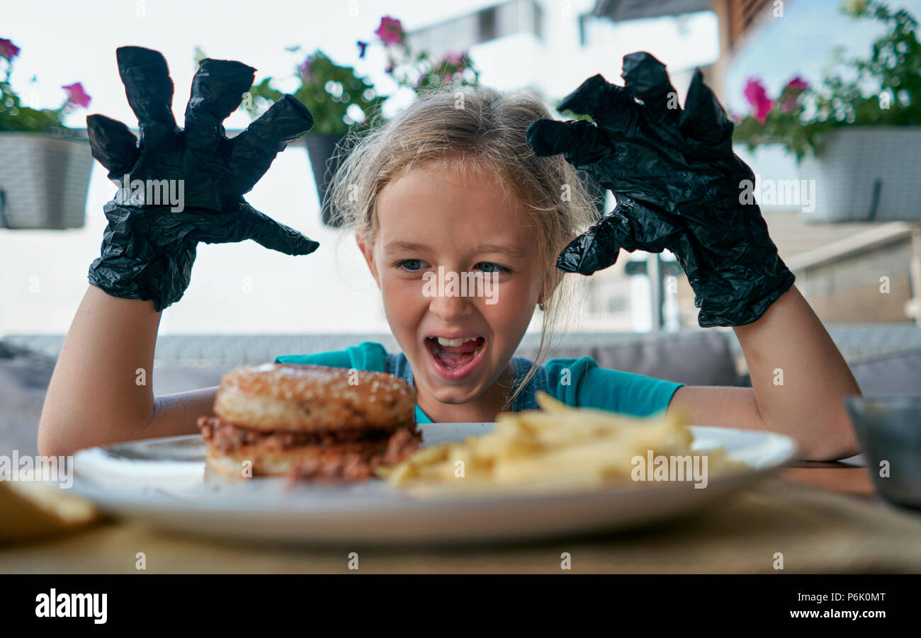 child eats a Burger in a restaurant Stock Photo - Alamy