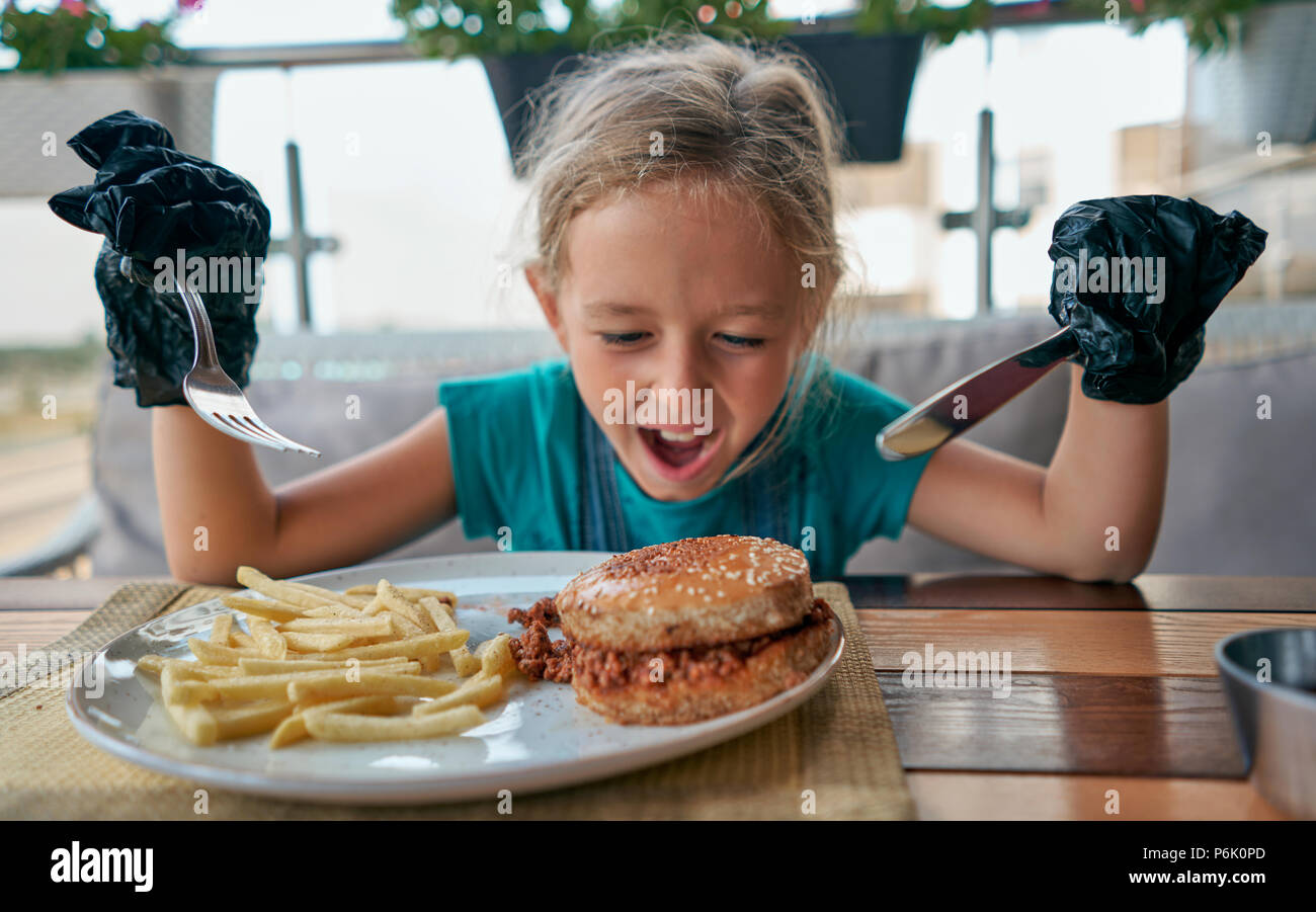 child eats a Burger in a restaurant Stock Photo - Alamy