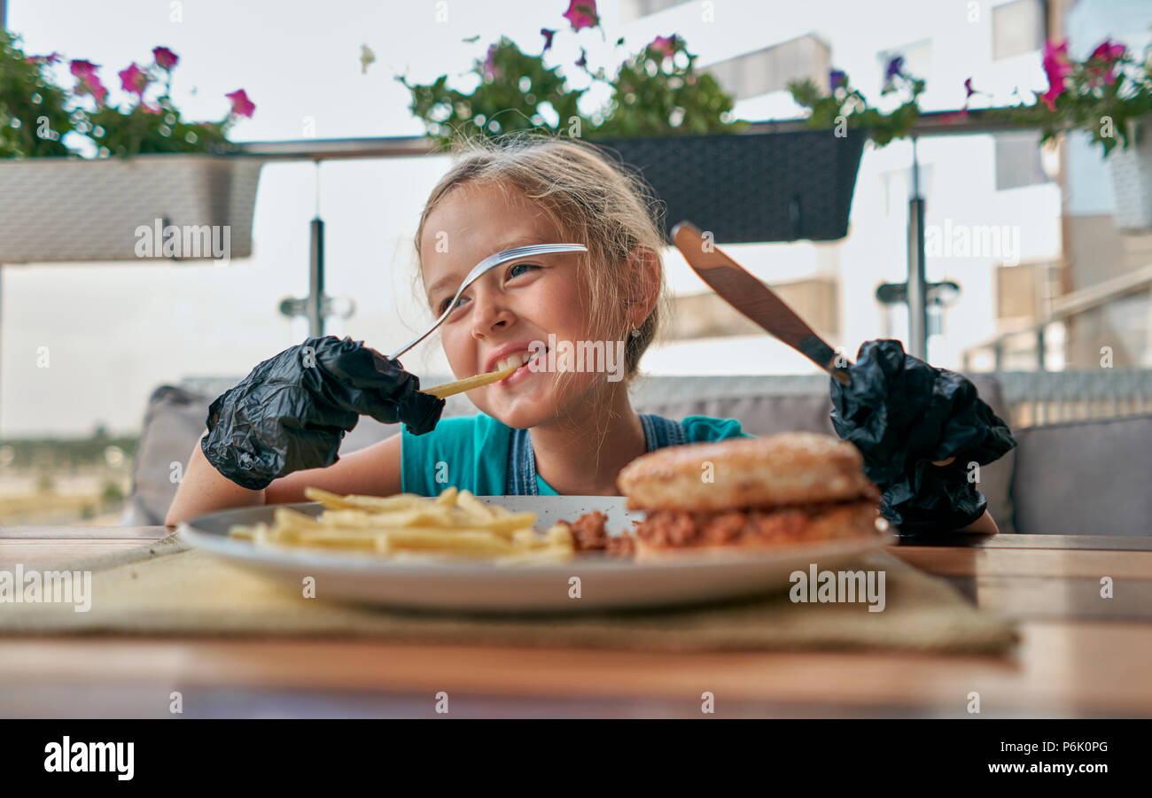 child eats a Burger in a restaurant Stock Photo - Alamy