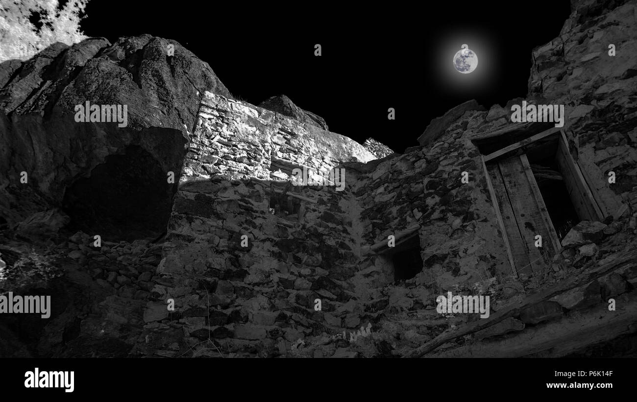 Moon rising over abandoned stone building Stock Photo - Alamy