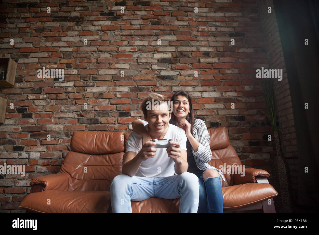 Happy millennial couple playing video games at home Stock Photo - Alamy