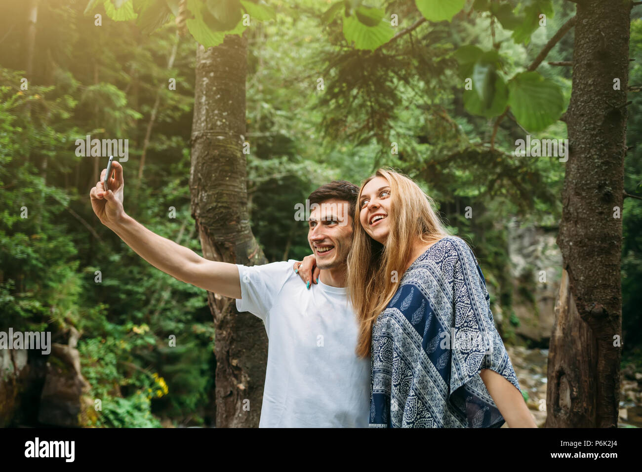 Beautiful young couple exploring in the park and makes selfie Stock ... Beautiful young couple exploring in the park and makes selfie Stock ...