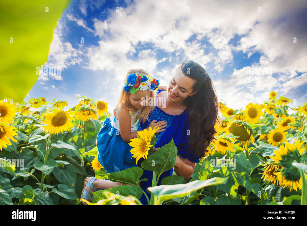 Mom and daughter among sunflowers Stock Photo - Alamy