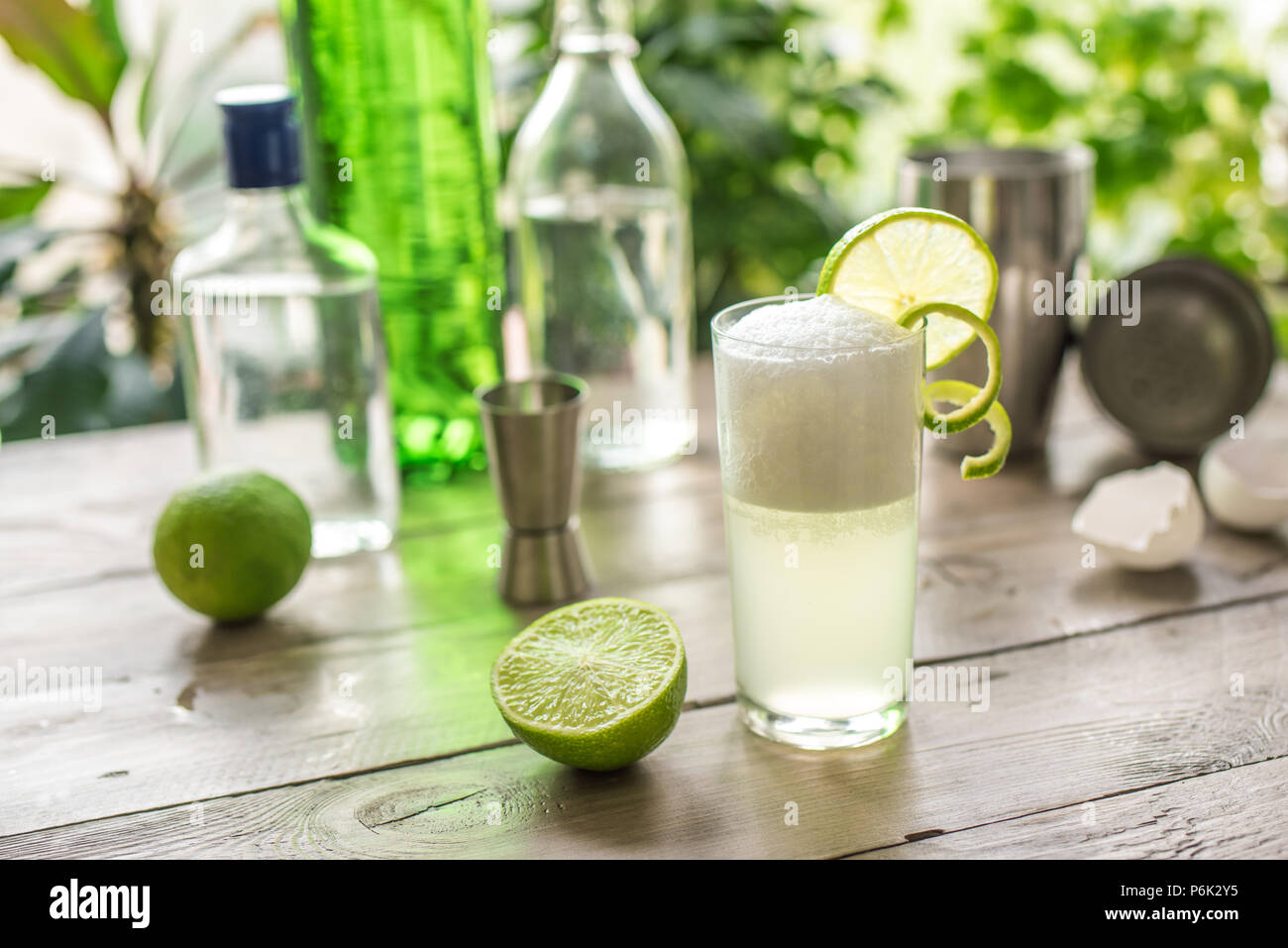 Egg Gin Fizz Cocktail with Lime Garnish. Making Gin Fizz Drink with ...