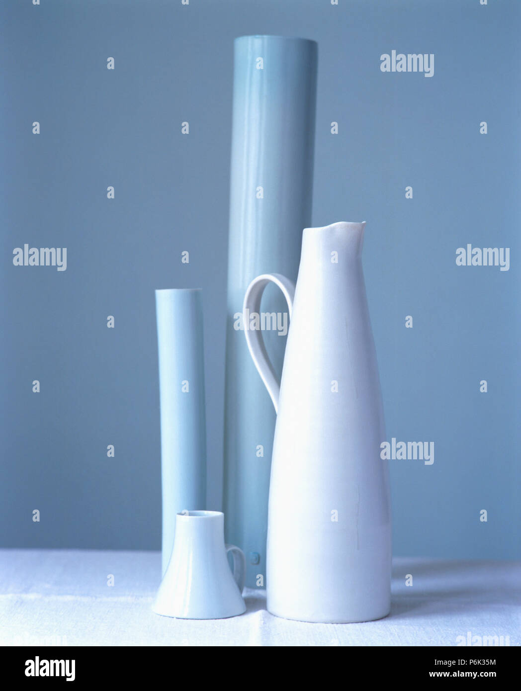 Close-up of tall white ceramic jug with white cylindrical vases Stock ...