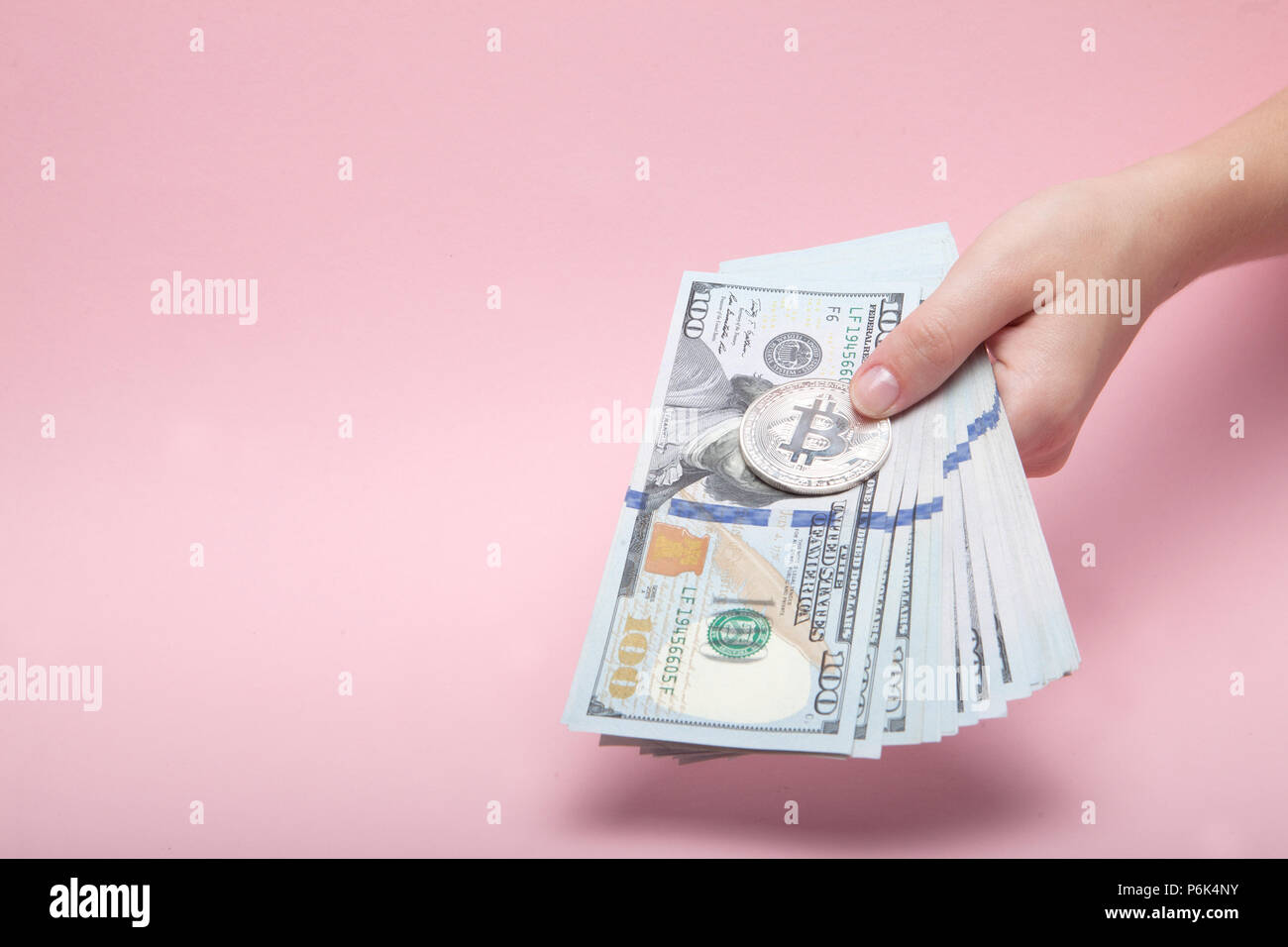 Pile of dollar s banknotes in female hand on pink background with copy ...