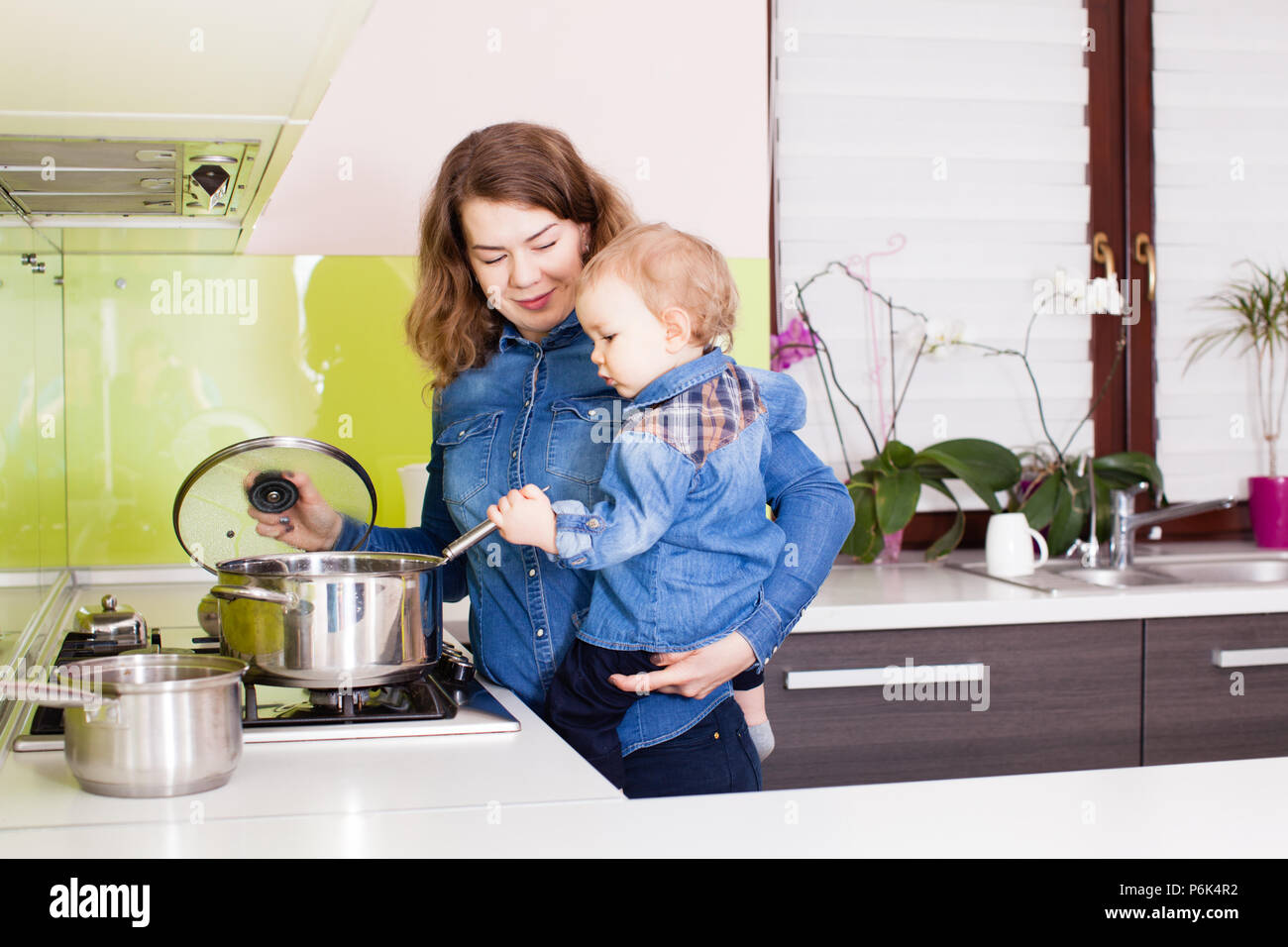 Mom with her child cooking dinner in the kitchen Stock Photo - Alamy