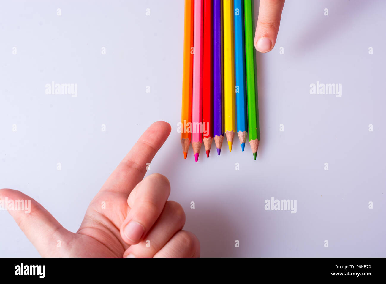 Hand holding color Pencils placed on a white background Stock Photo - Alamy
