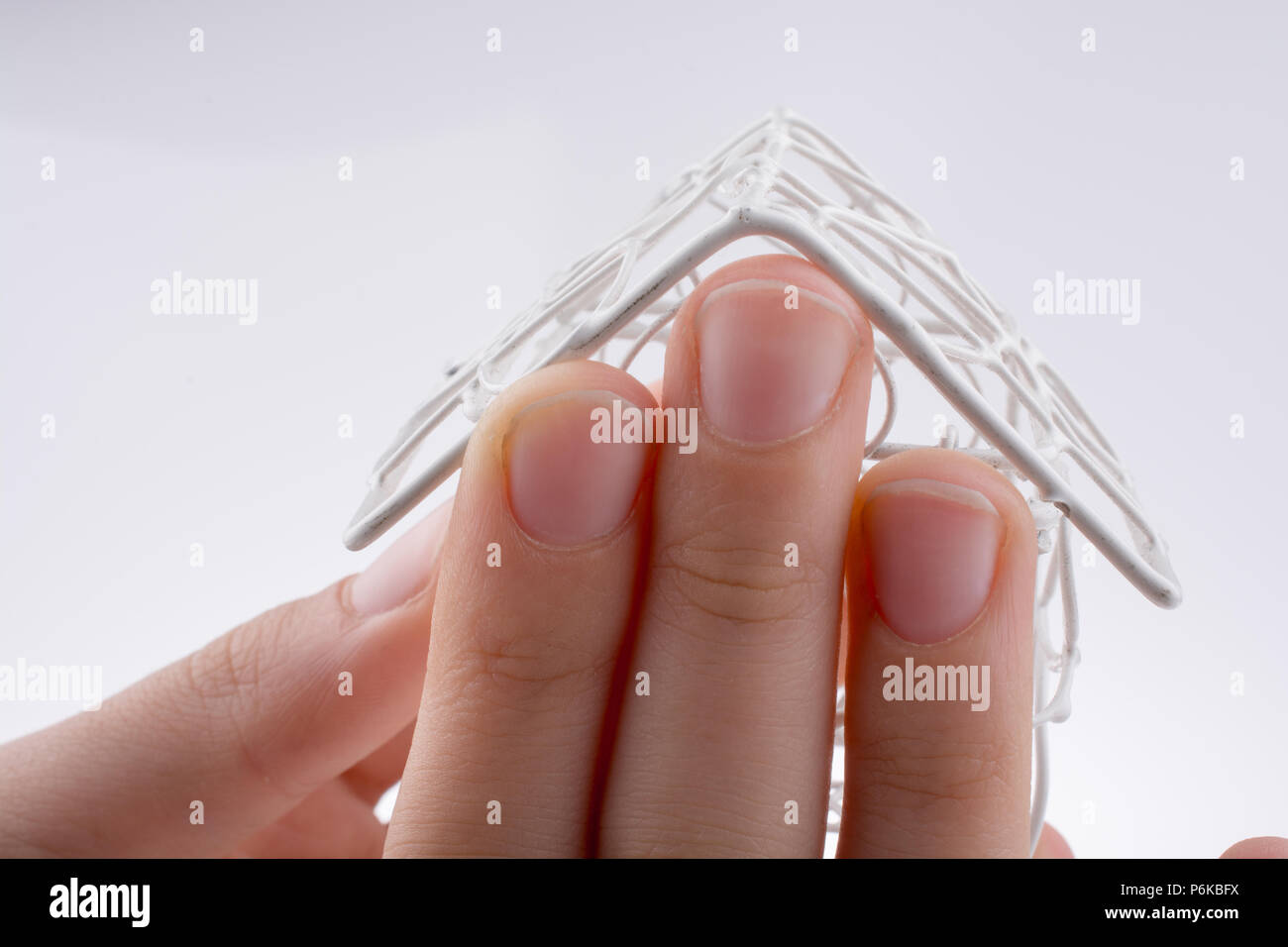 Little model house made of white metal wire in hand Stock Photo - Alamy