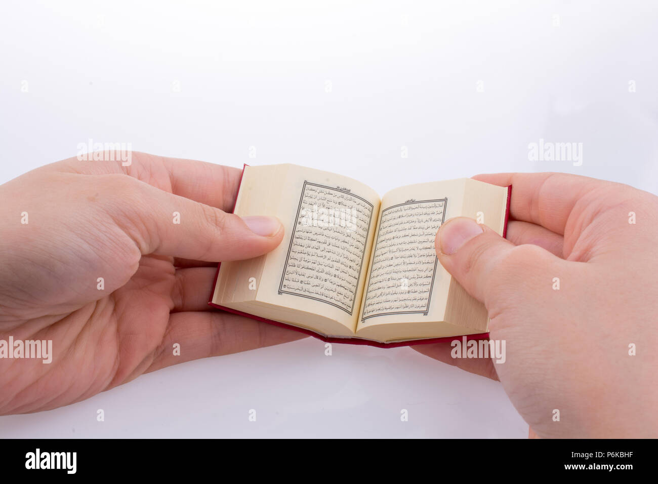 Hand holding The Holy Quran on a white background Stock Photo - Alamy
