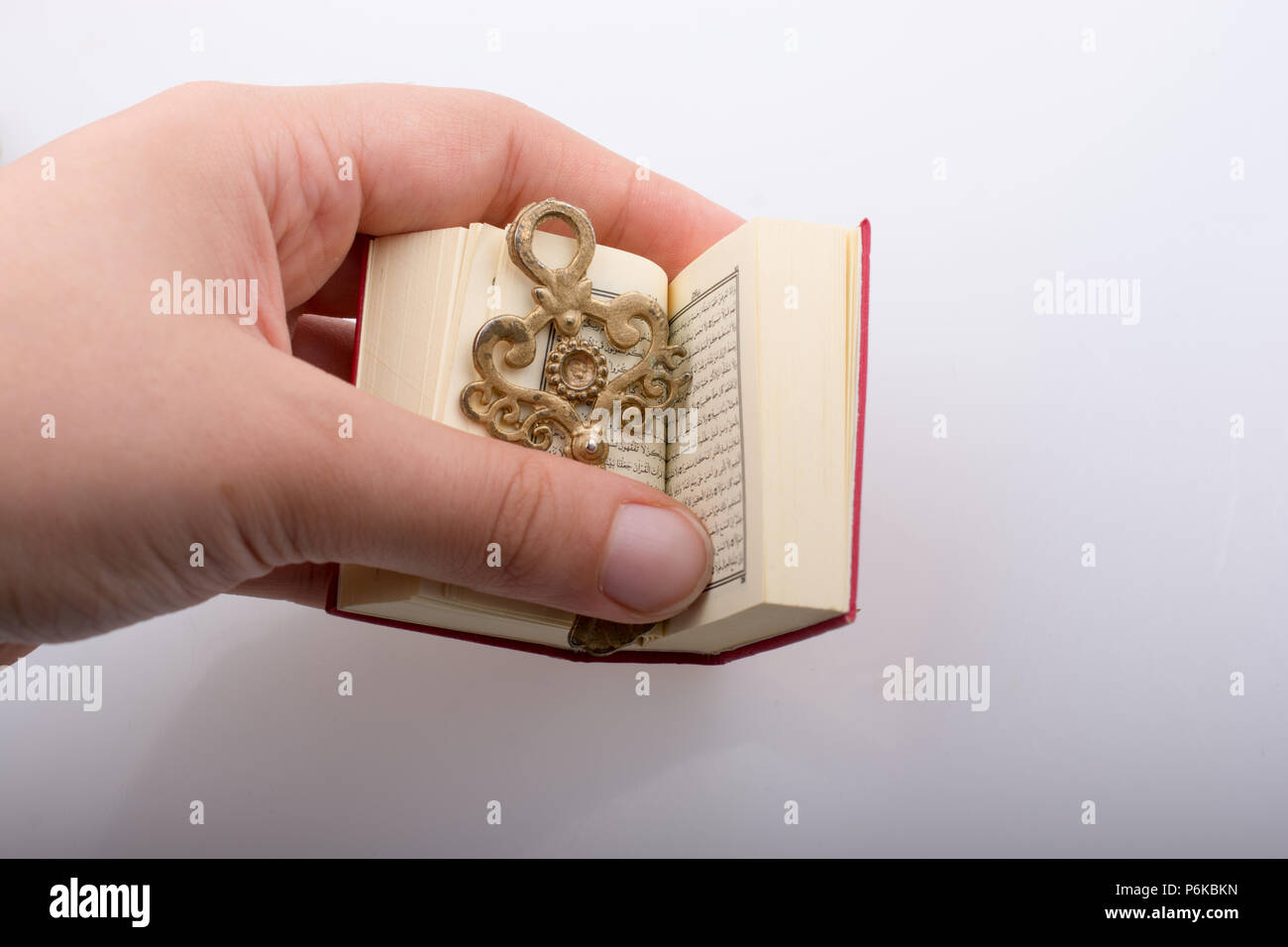 Hand holding Key and Islamic Holy Book Quran in mini size Stock Photo ...
