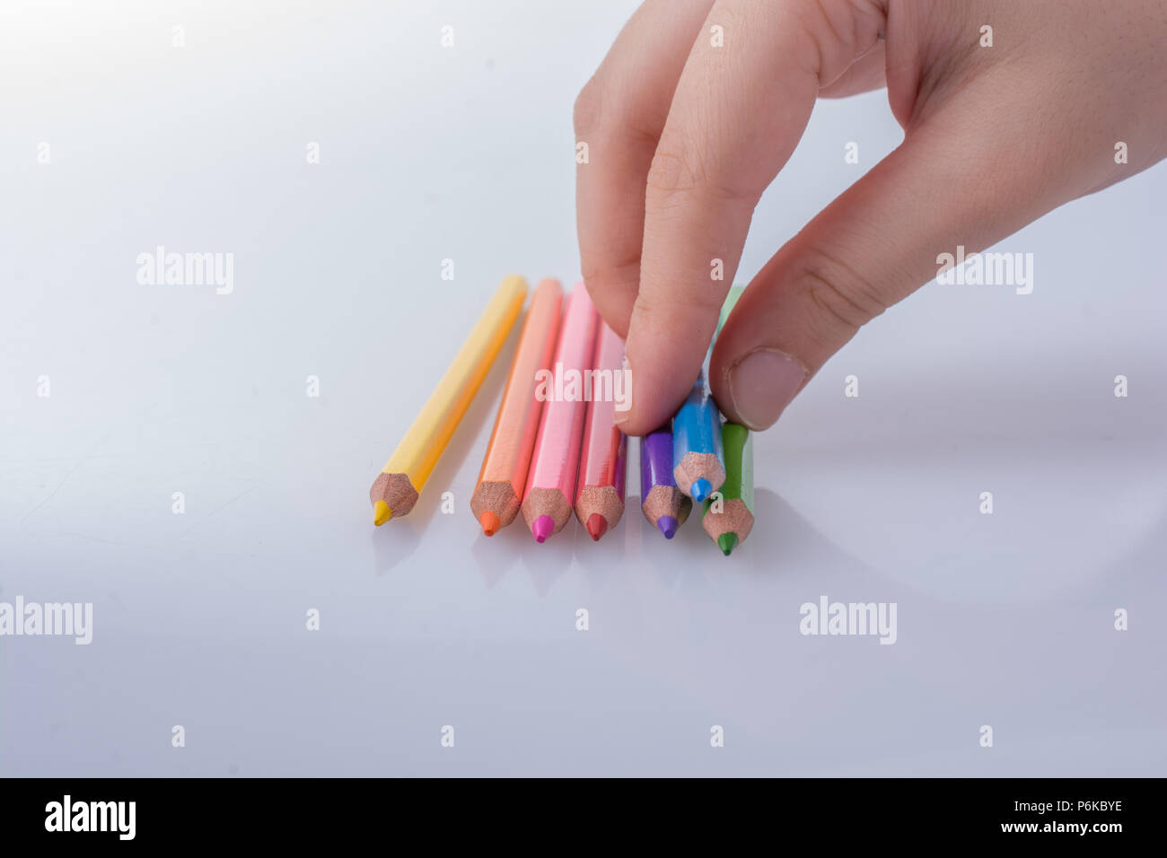 Hand holding color Pencils placed on a white background Stock Photo - Alamy
