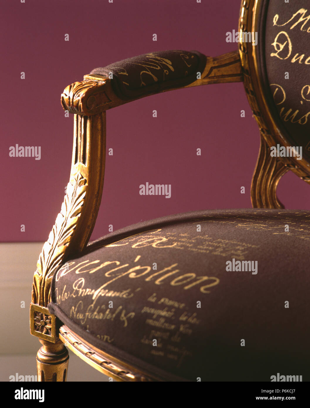 Close-up of French-style chair with gilt lettering on upholstered seat ...