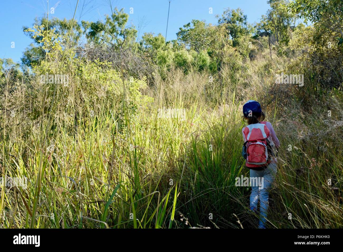 Child walks through long grass in a remote area, Many peaks hike to ...