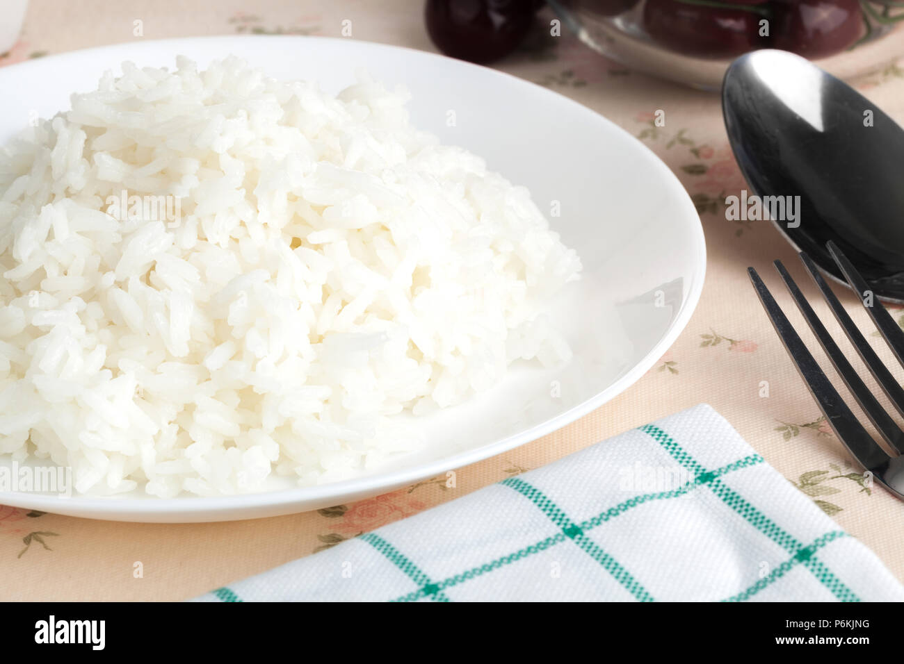 Cooked plain white jasmine rice serve in a dish. Close up on the table ...