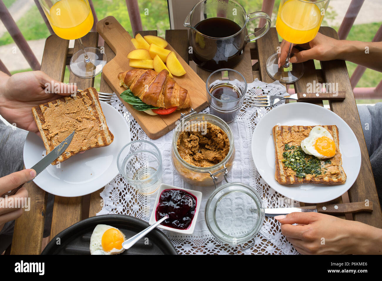 Couple having Breakfast on the balcony. Breakfast with toast, jam and ...