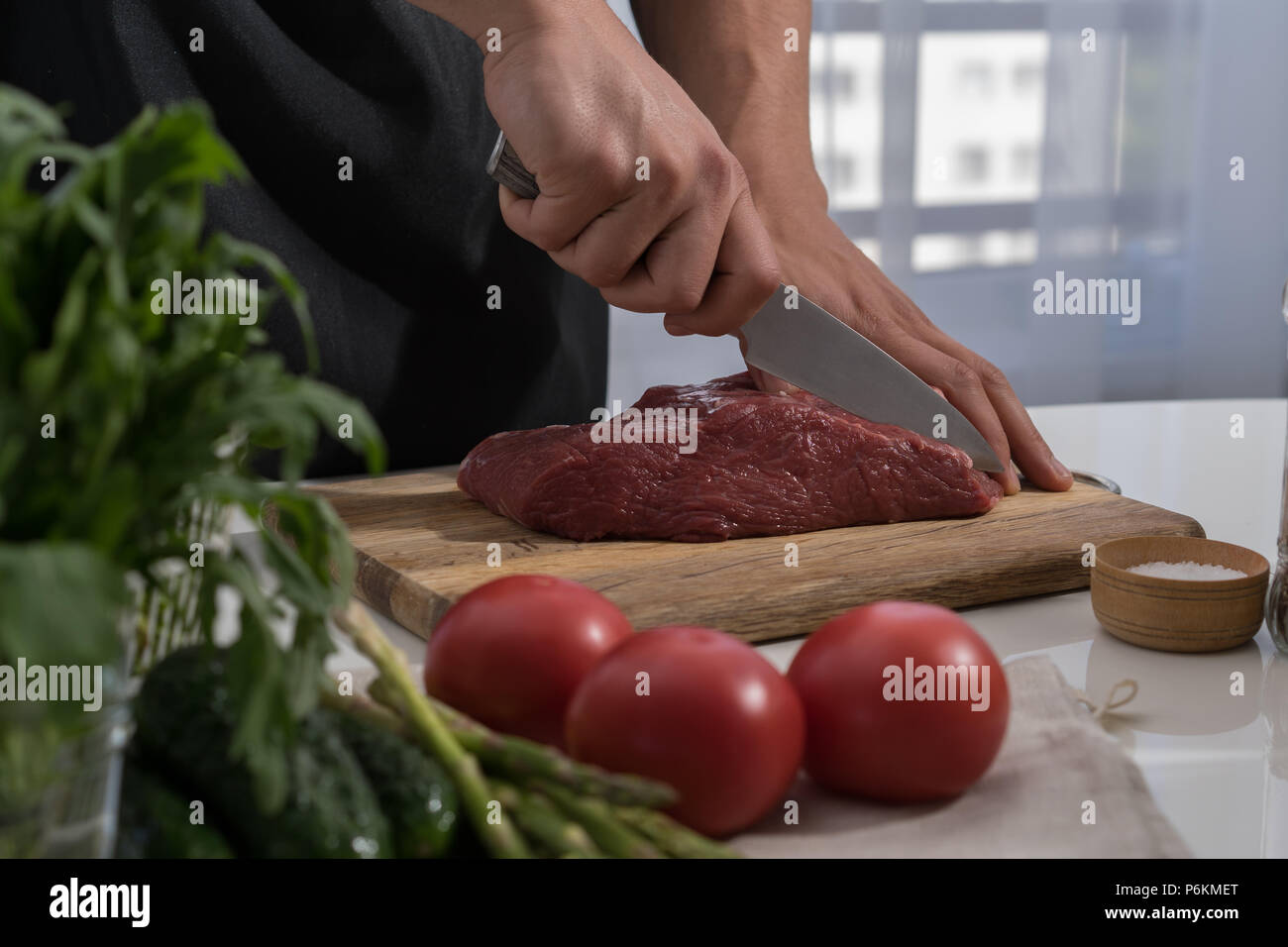 Butcher cutting beef in the kitchen Stock Photo - Alamy