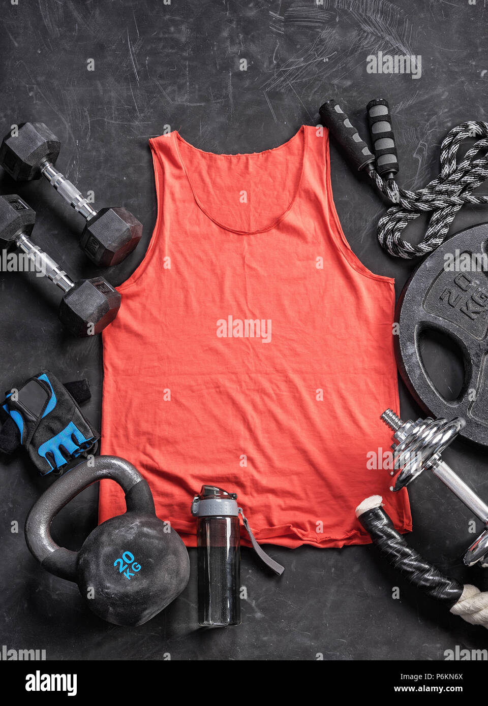 Red t-shirt and sports equipment on a black background. Top view ...